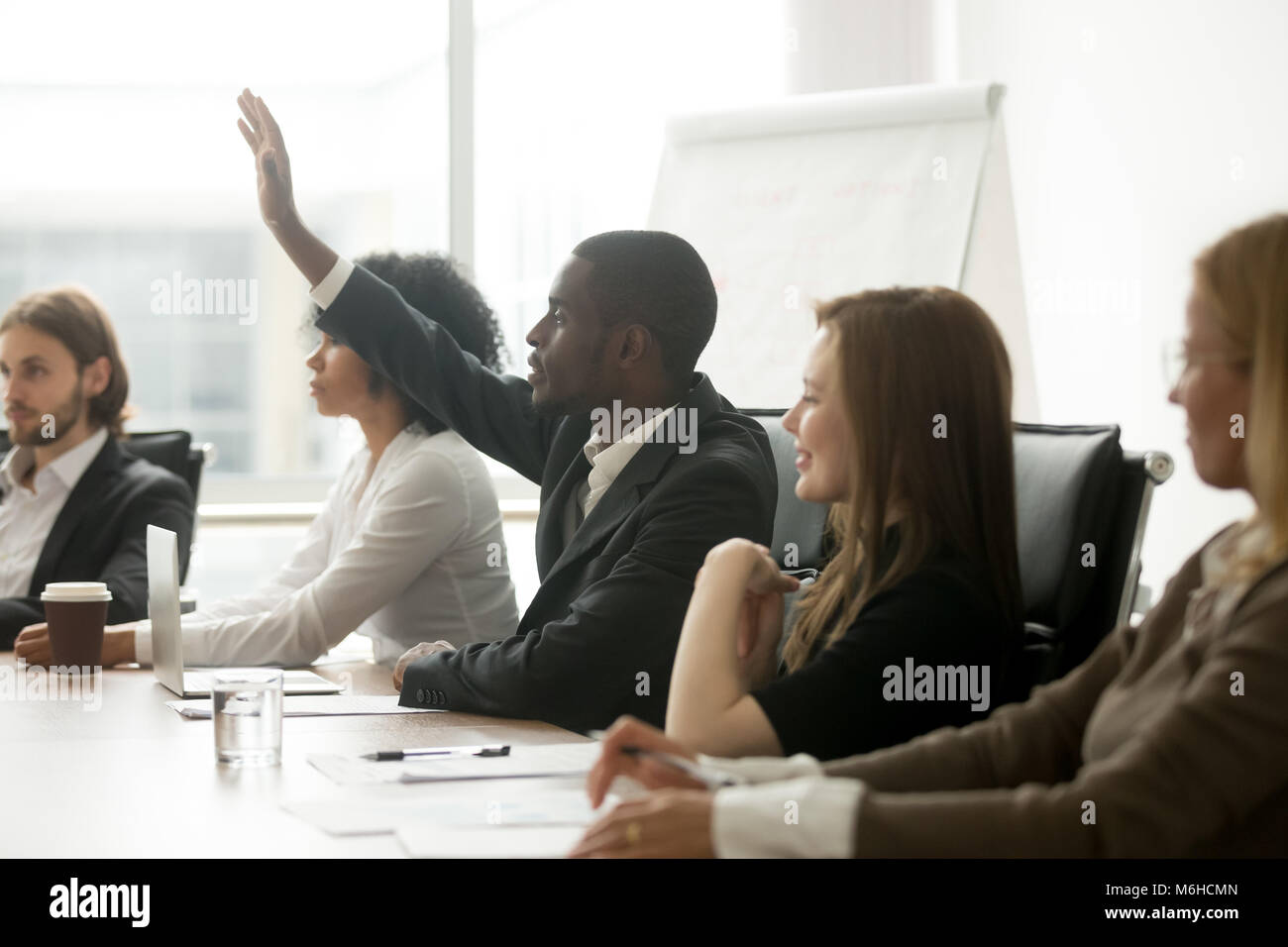 African Businessman Raising Hand Asking Question At Diverse Team Stock