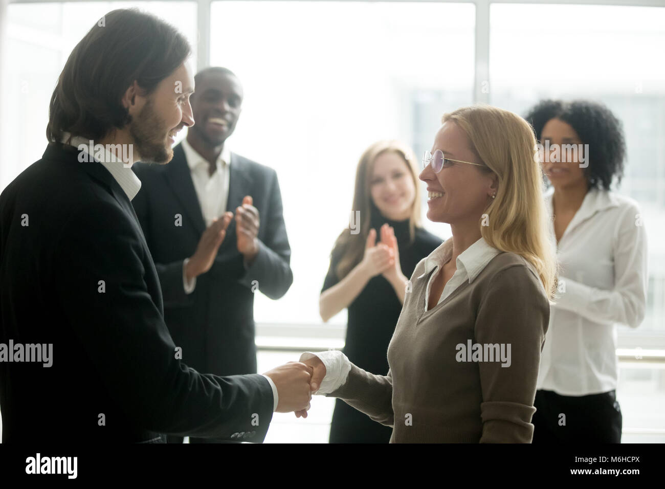Boss handshaking employee congratulating with promotion while di Stock ...