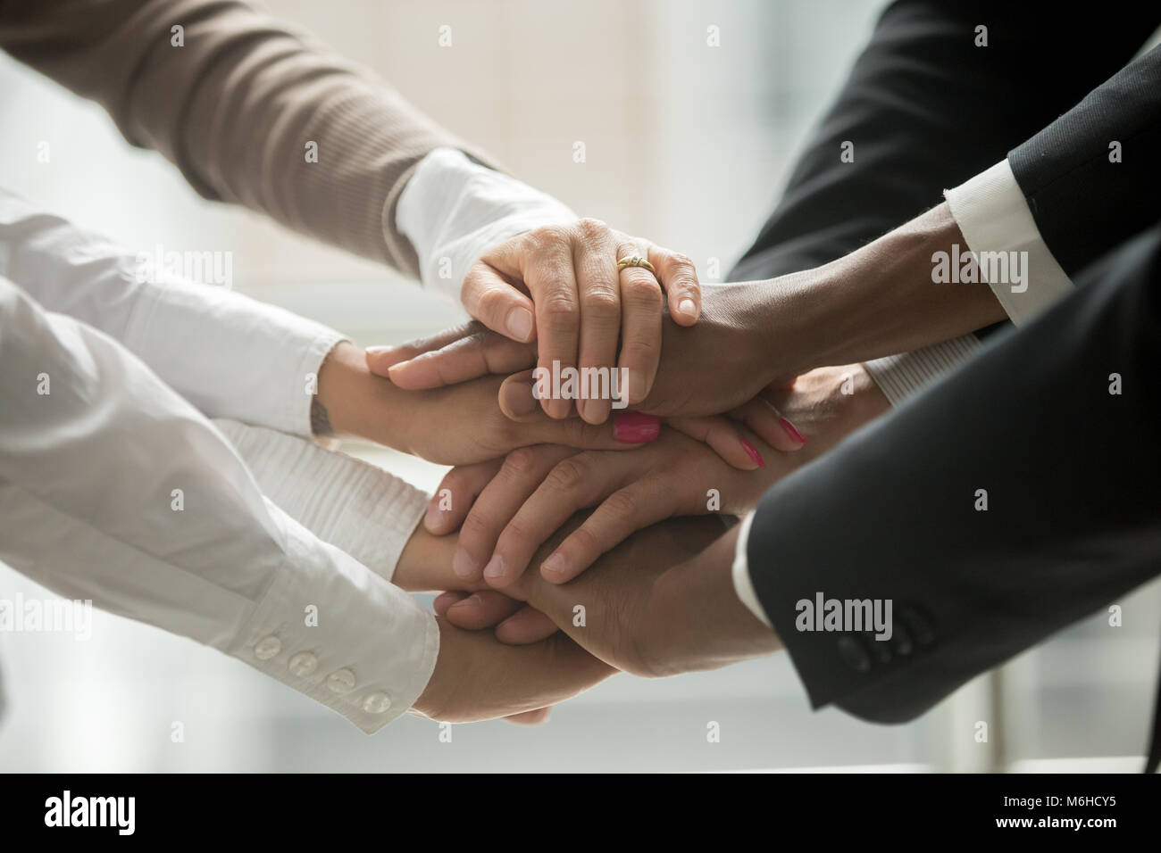 Diverse people putting hands together promising help and support Stock ...