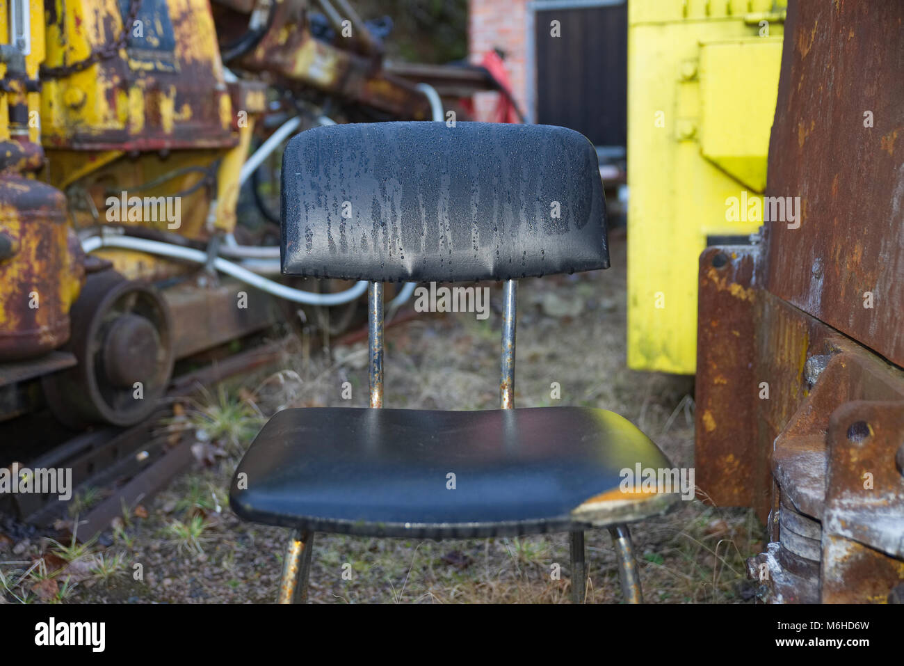 An old chair with torn upholstery among rusty mining equipment Stock ...