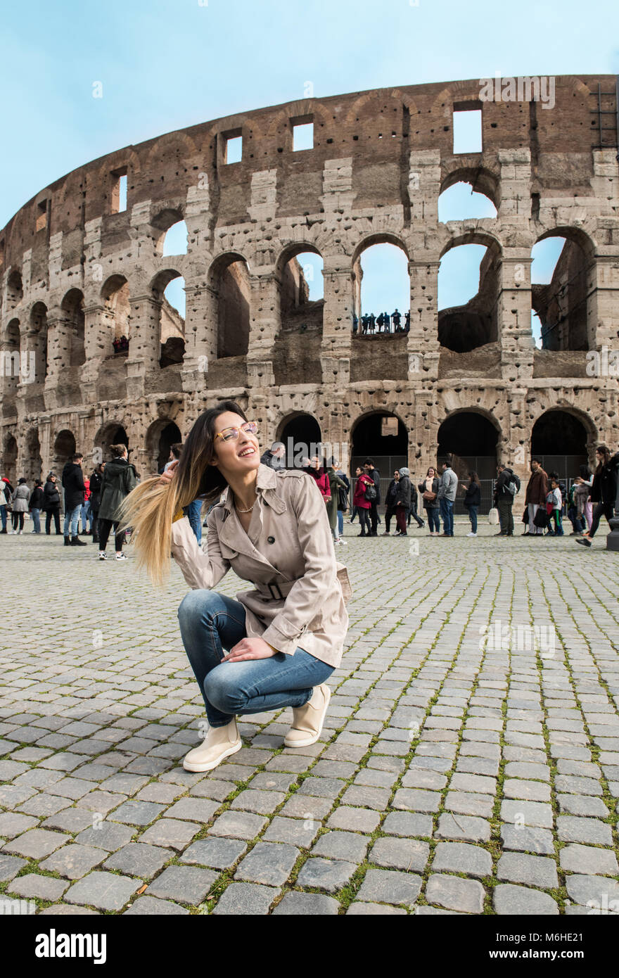 Young pretty tourist woman smiling with travel book, colosseum monument ...