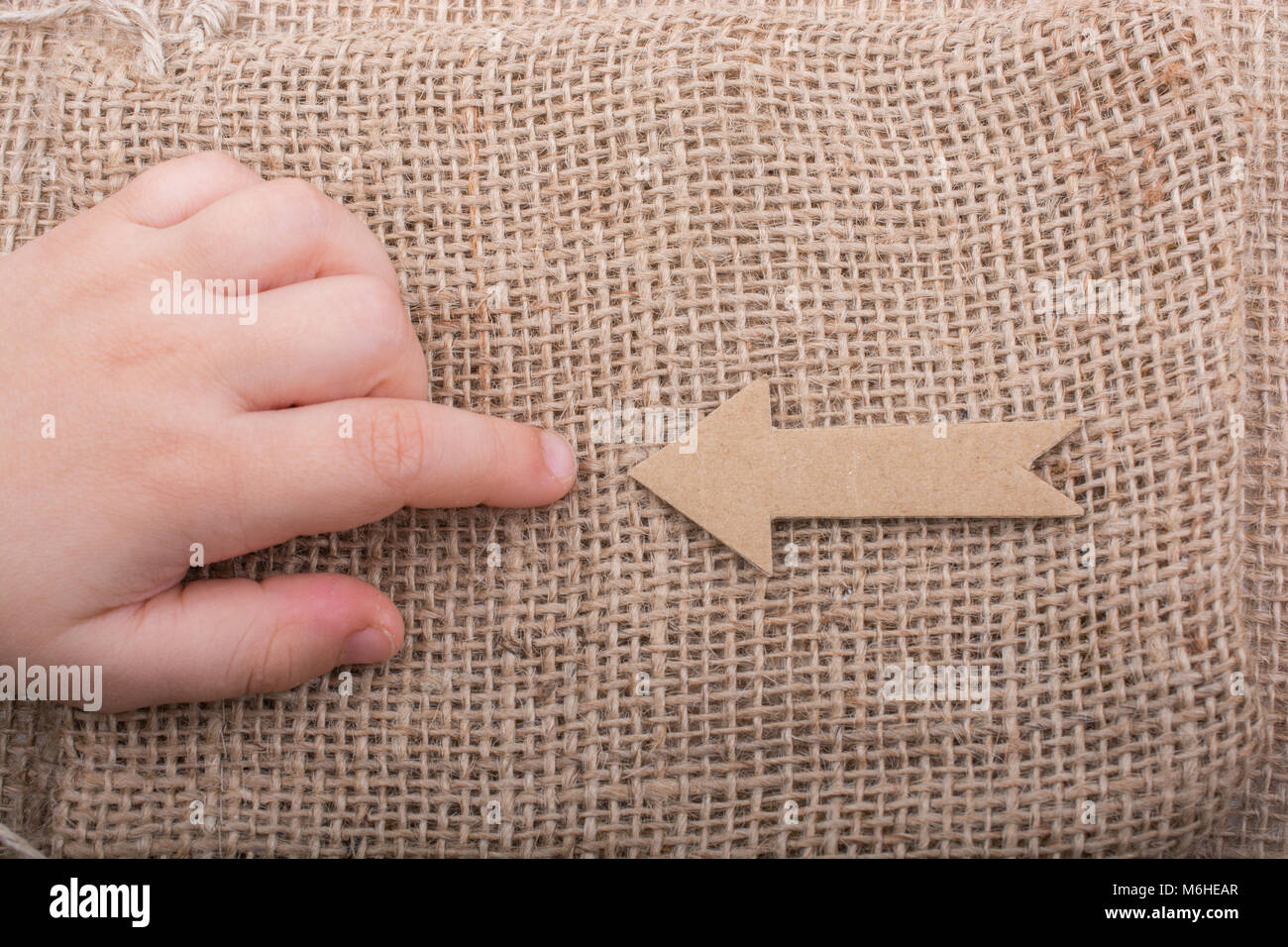 Arrow sign cut out of brown paper on canvas Stock Photo - Alamy