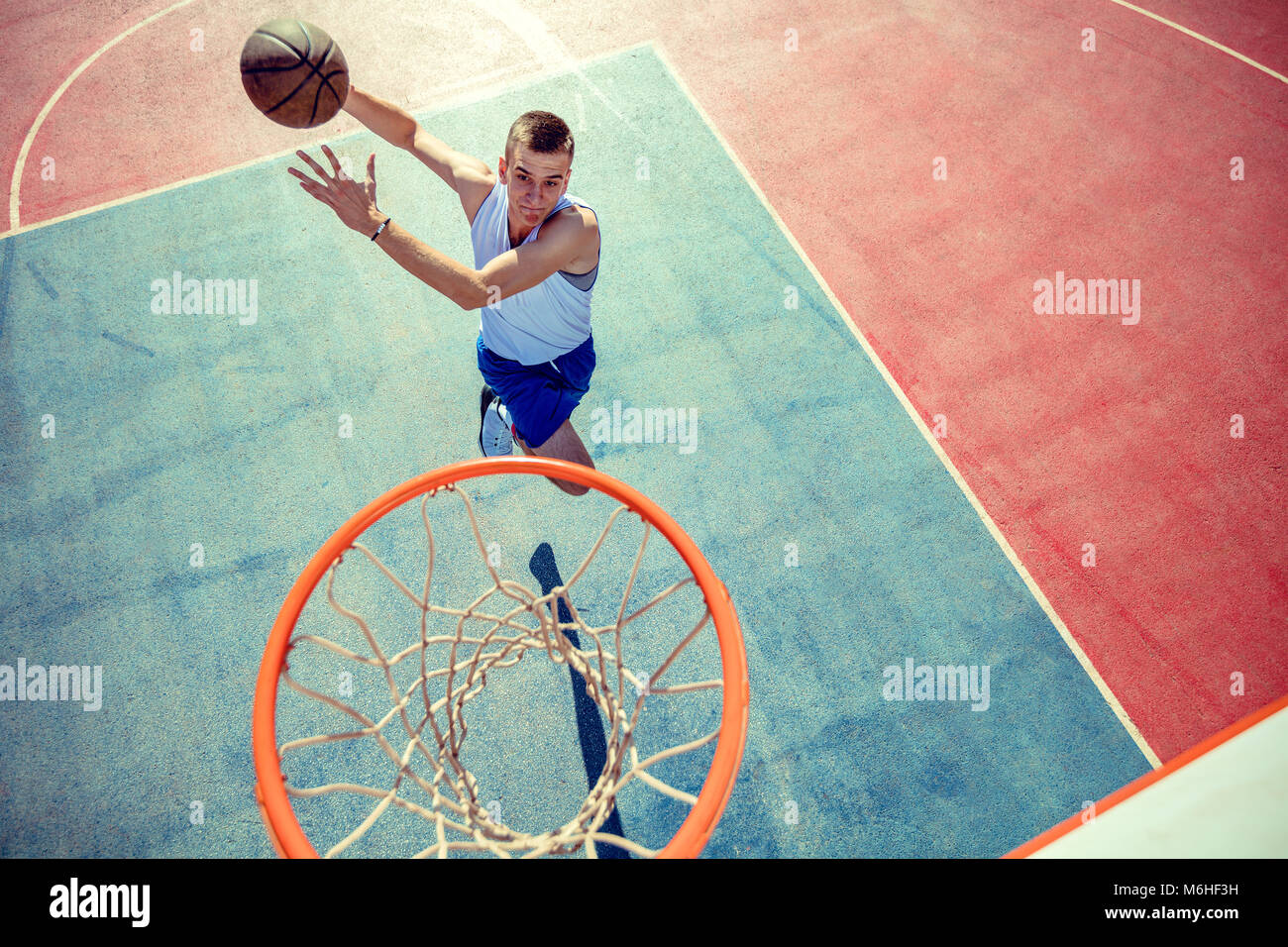 High angle view of basketball player dunking basketball in hoop Stock ...