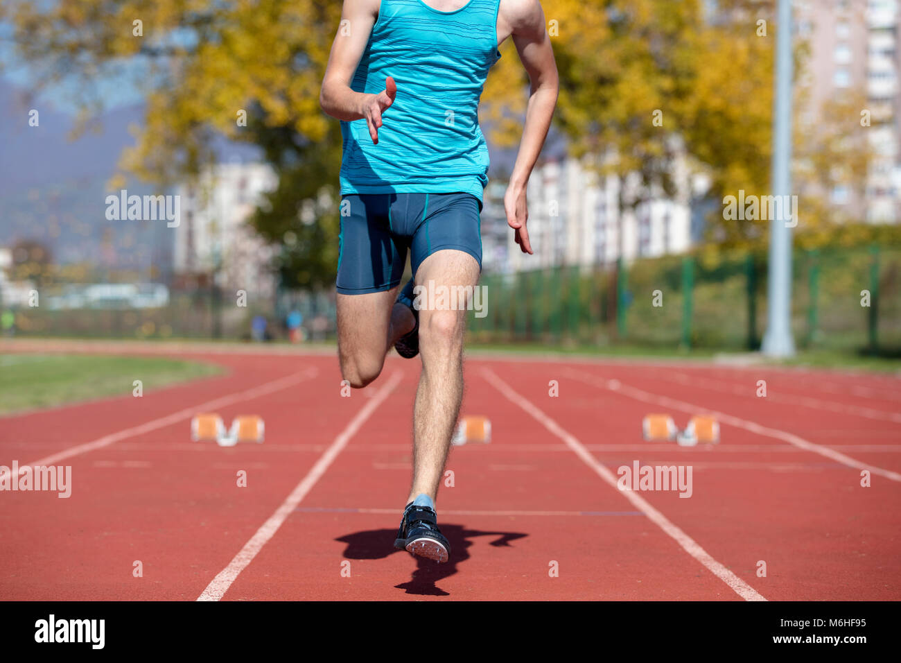 Man runner in blue shirt and shorts and sport shoes in steady position ...