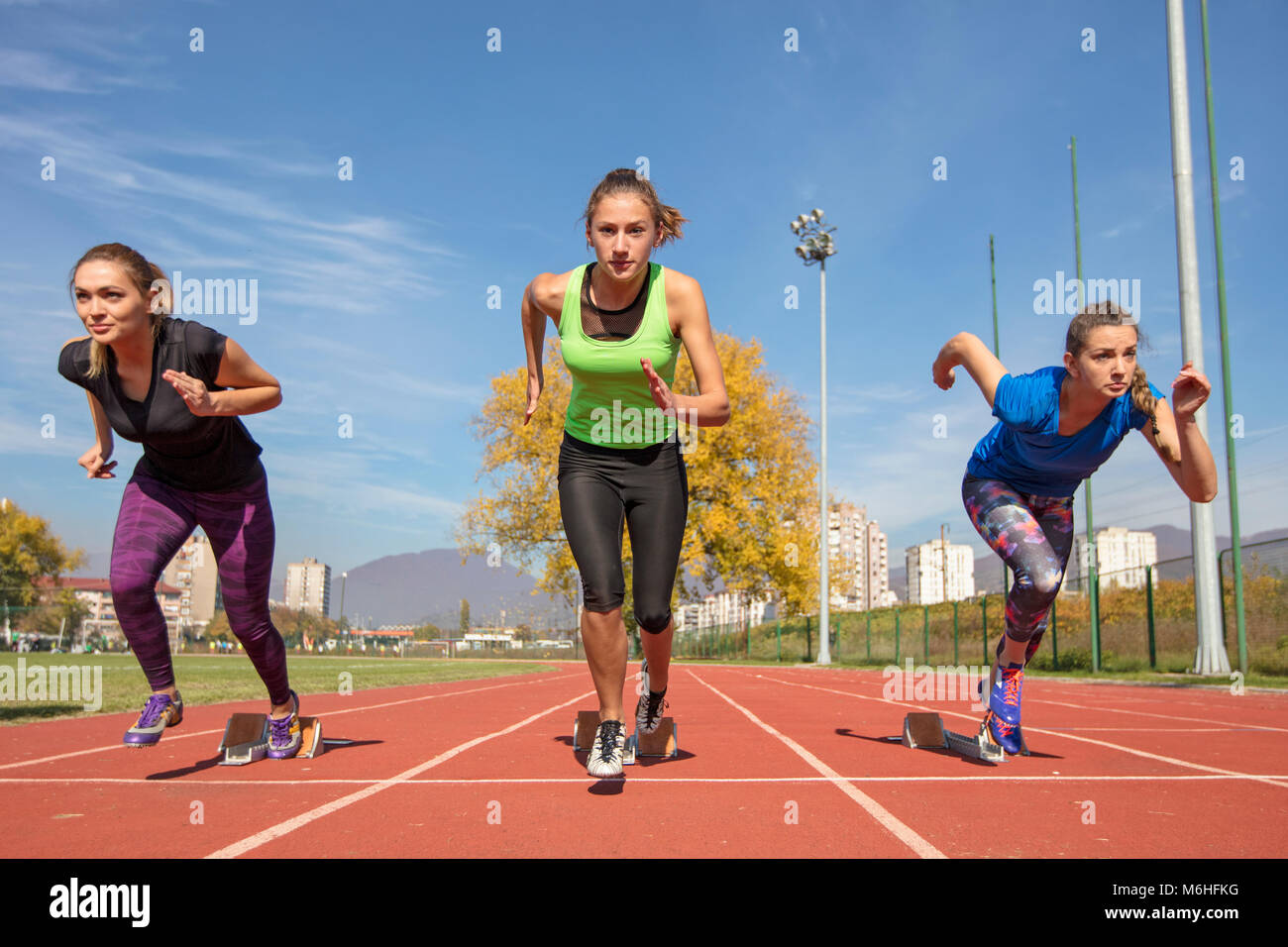 Women ready to race on track field Stock Photo - Alamy