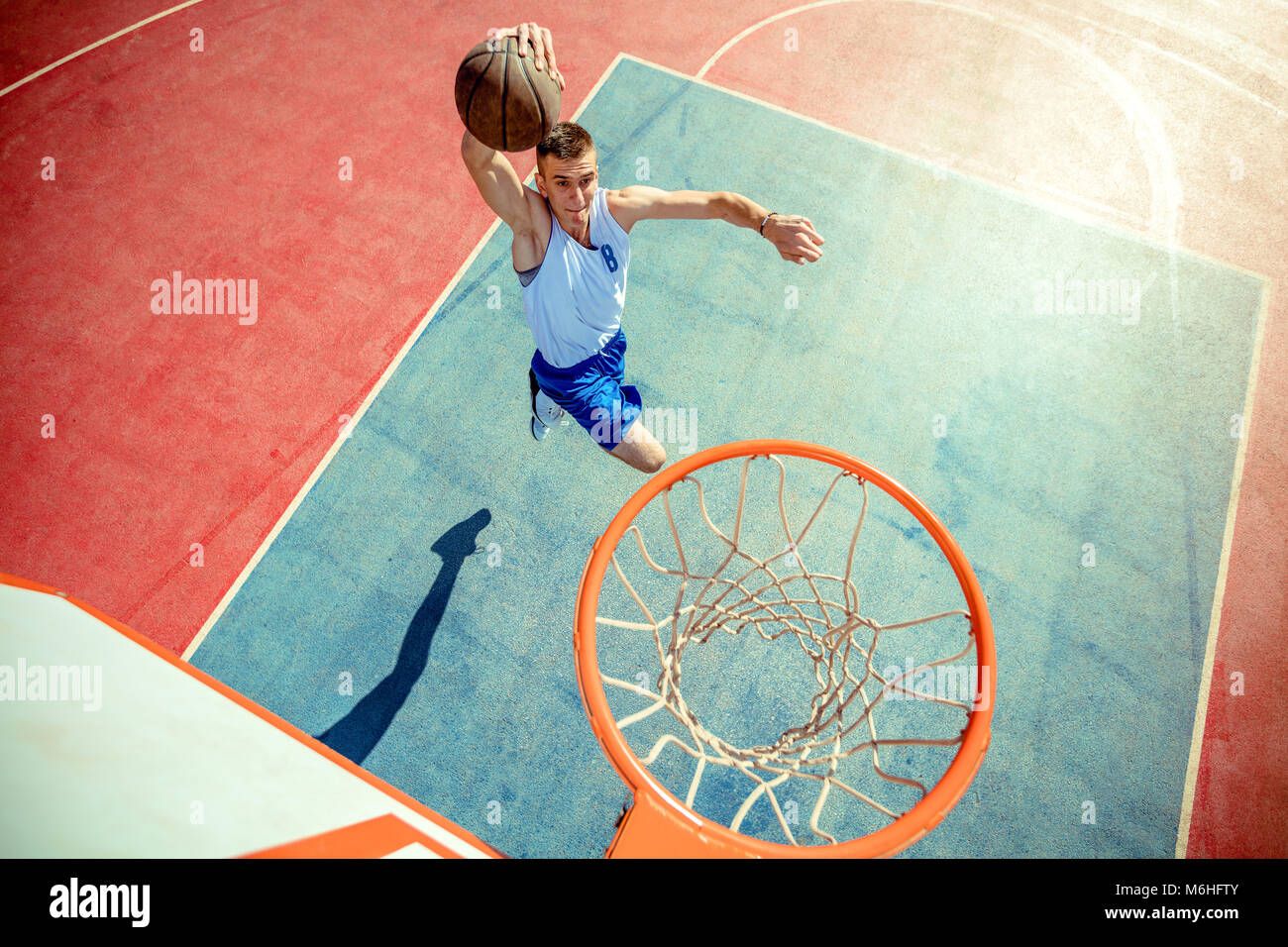 High angle view of basketball player dunking basketball in hoop Stock ...
