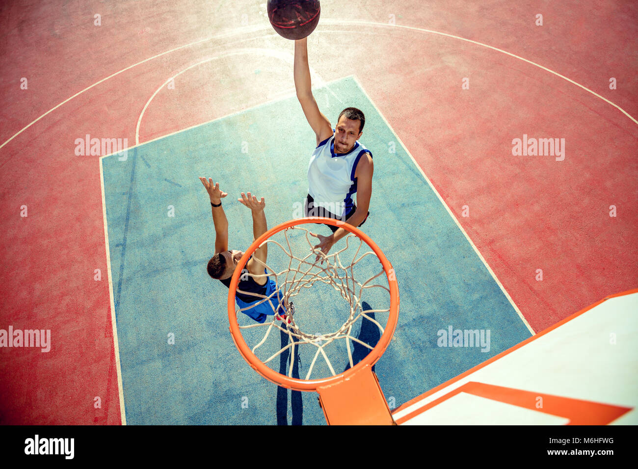 High angle view of basketball player dunking basketball in hoop Stock ...