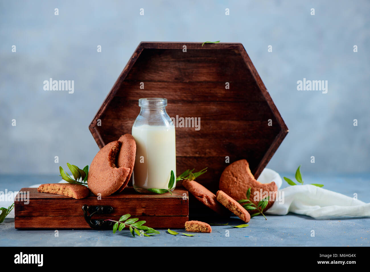 Milk and cookies with a bottle and wooden tray. High key food ...