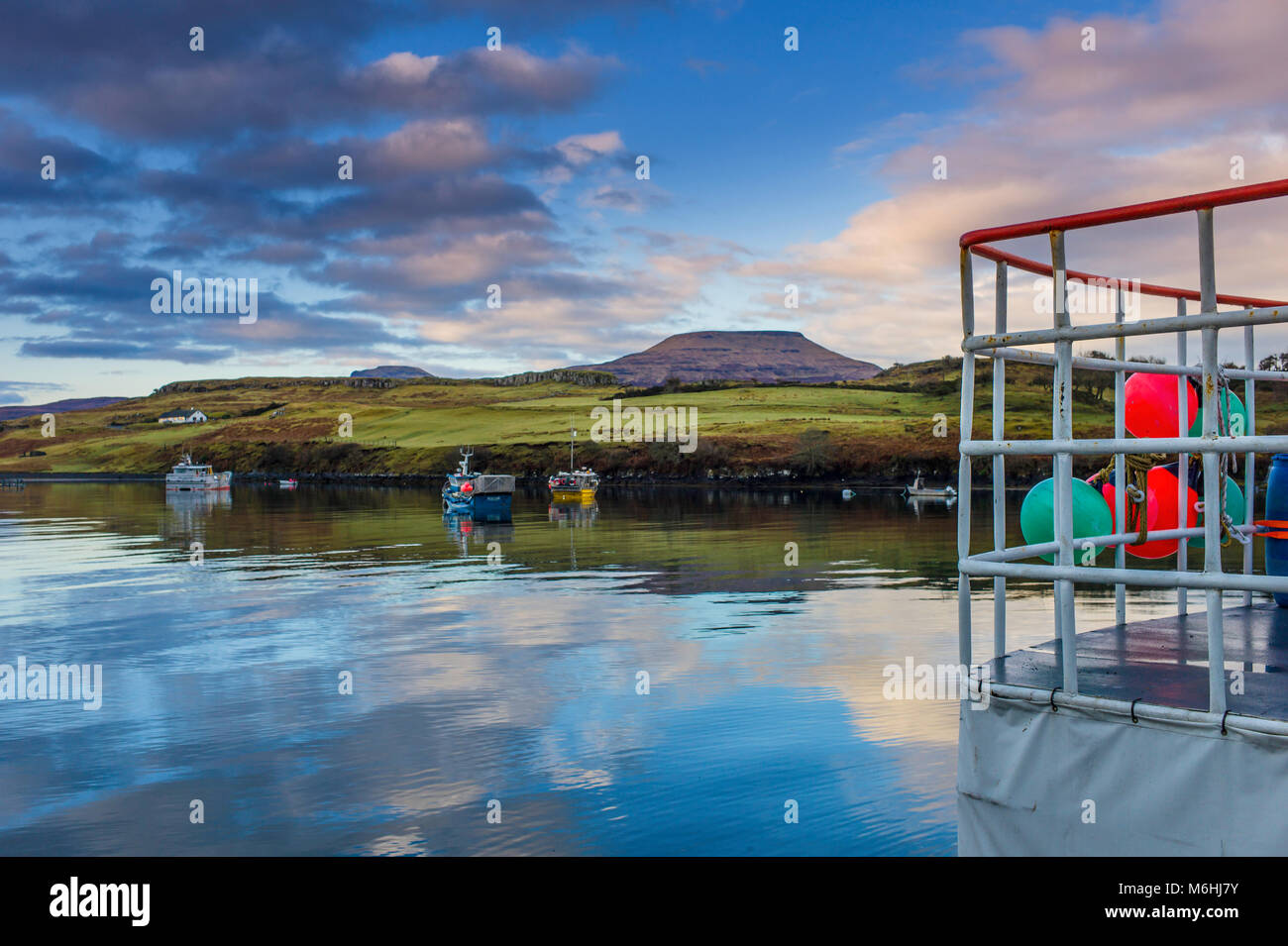 Dunvegan harbour with the stern of a prawn boat in the foreground and ...