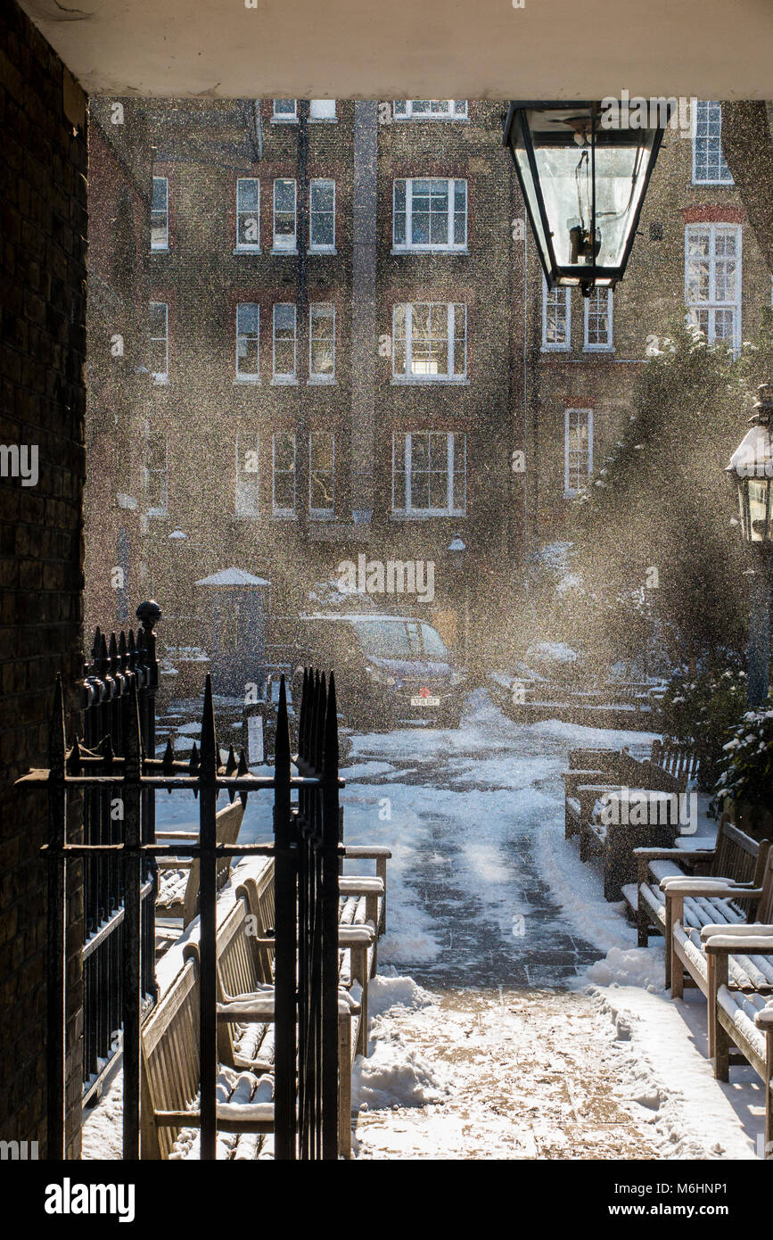 Early morning light catches snowflakes as snow falls in central London ...