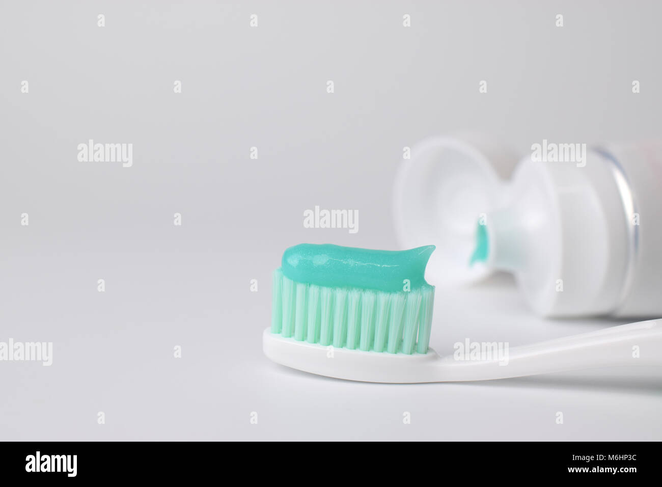 Green toothpaste on a toothbrush on white background - closeup Stock ...
