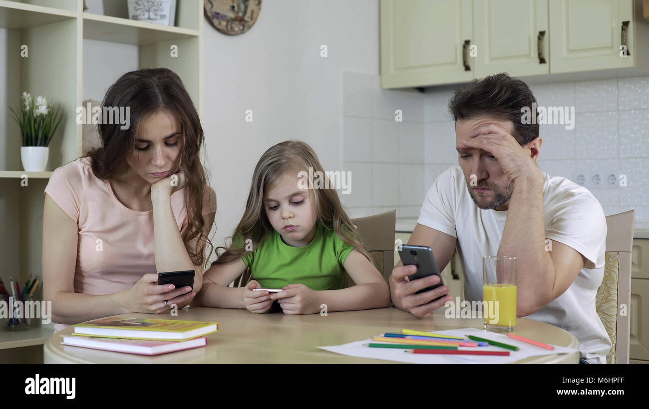 Family using gadgets at home ignoring each other, lack of live ...