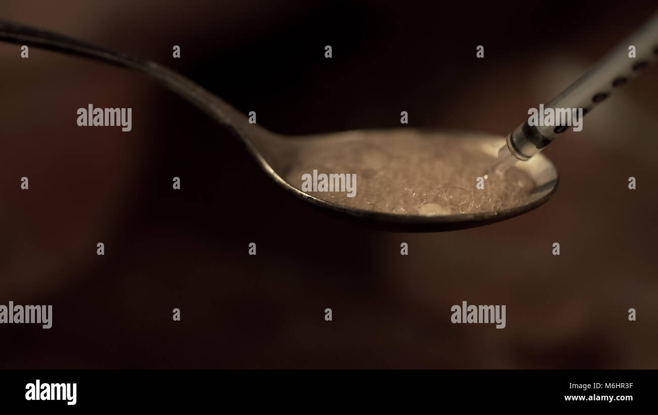 Syringe withdrawing heroin boiling on spoon, substance dependence ...