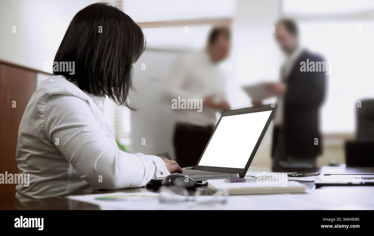 Female employee typing minutes on computer in meeting, men discussing ...