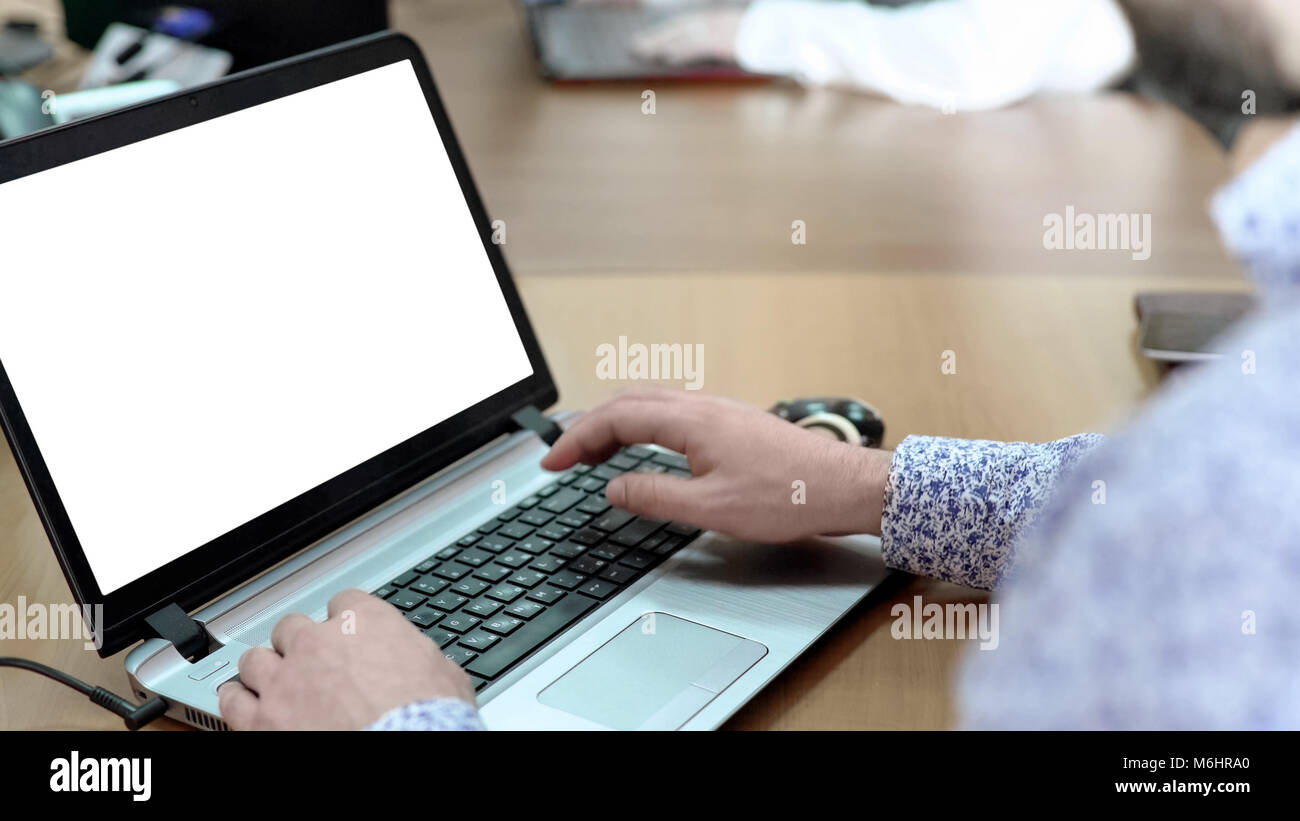 Male employee working on laptop at office desk, developing business ...