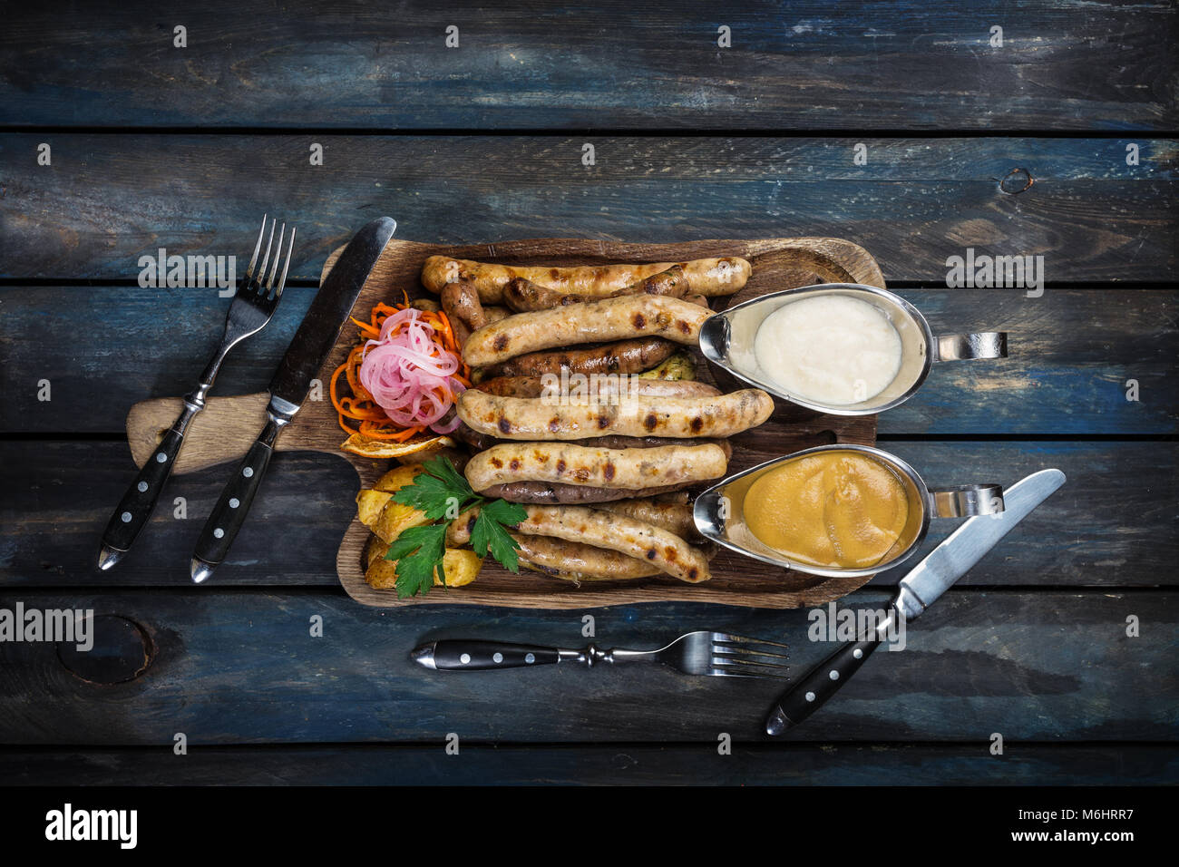 Smoked sausage with sauerkraut and potato wedges Stock Photo - Alamy