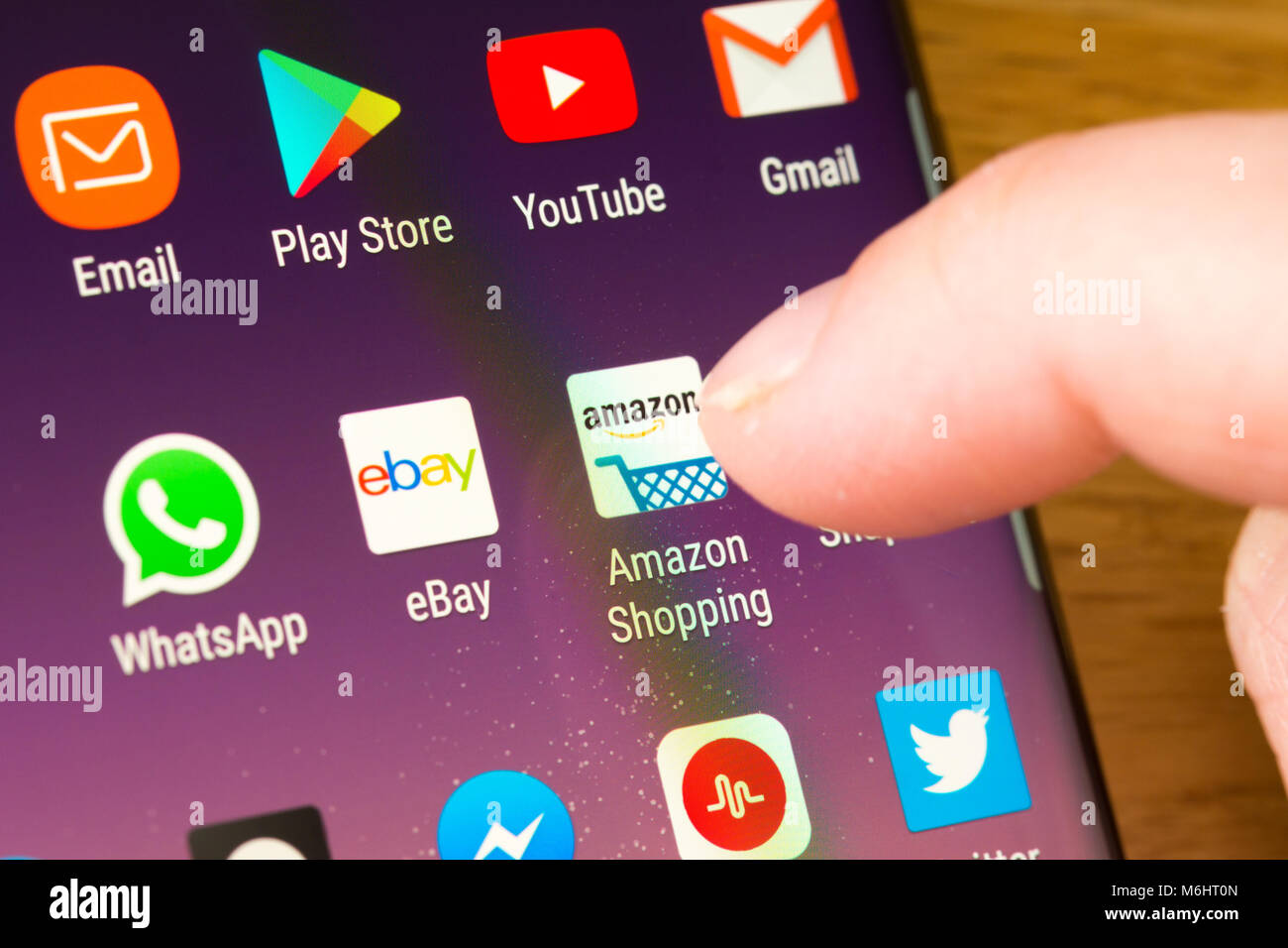 Closeup of the Amazon Shopping app on a smartphone being selected by a ...