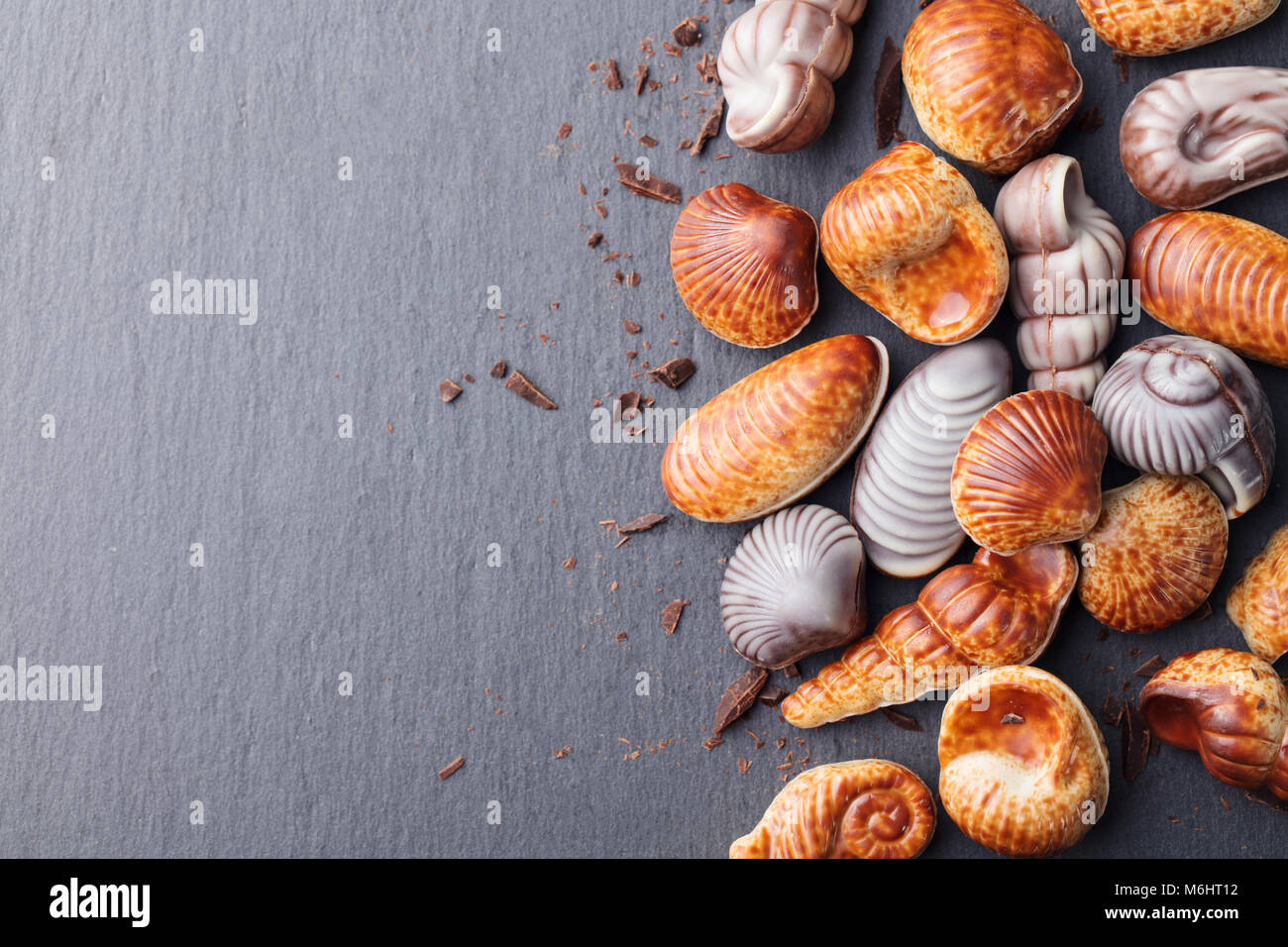 Chocolate candies, traditional Belgian shell shape. Black slate ...