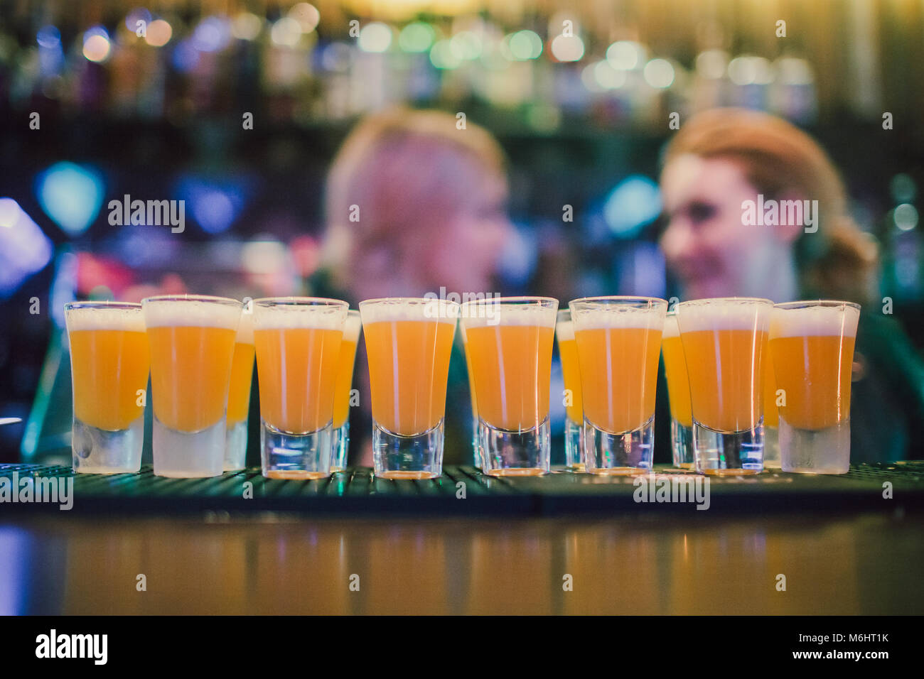 Beautiful row line of different colored alcohol cocktails with mint on ...