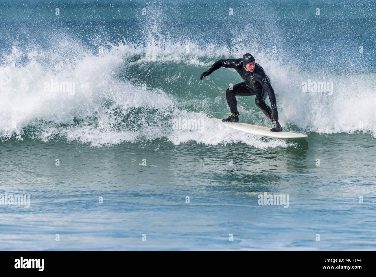 A surfer riding a wave during the winter at Fistral Newquay Cornwall ...