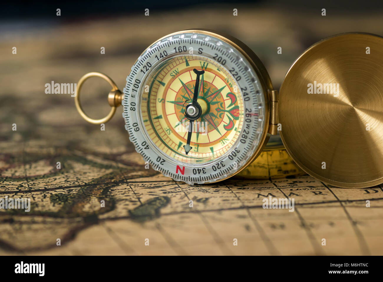 Old compass on vintage map. Retro stale Stock Photo - Alamy