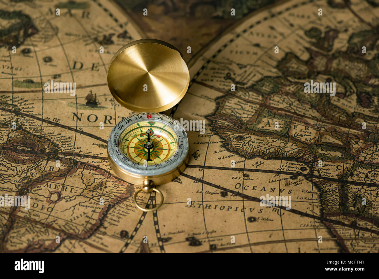 Old compass on vintage map. Retro stale Stock Photo - Alamy