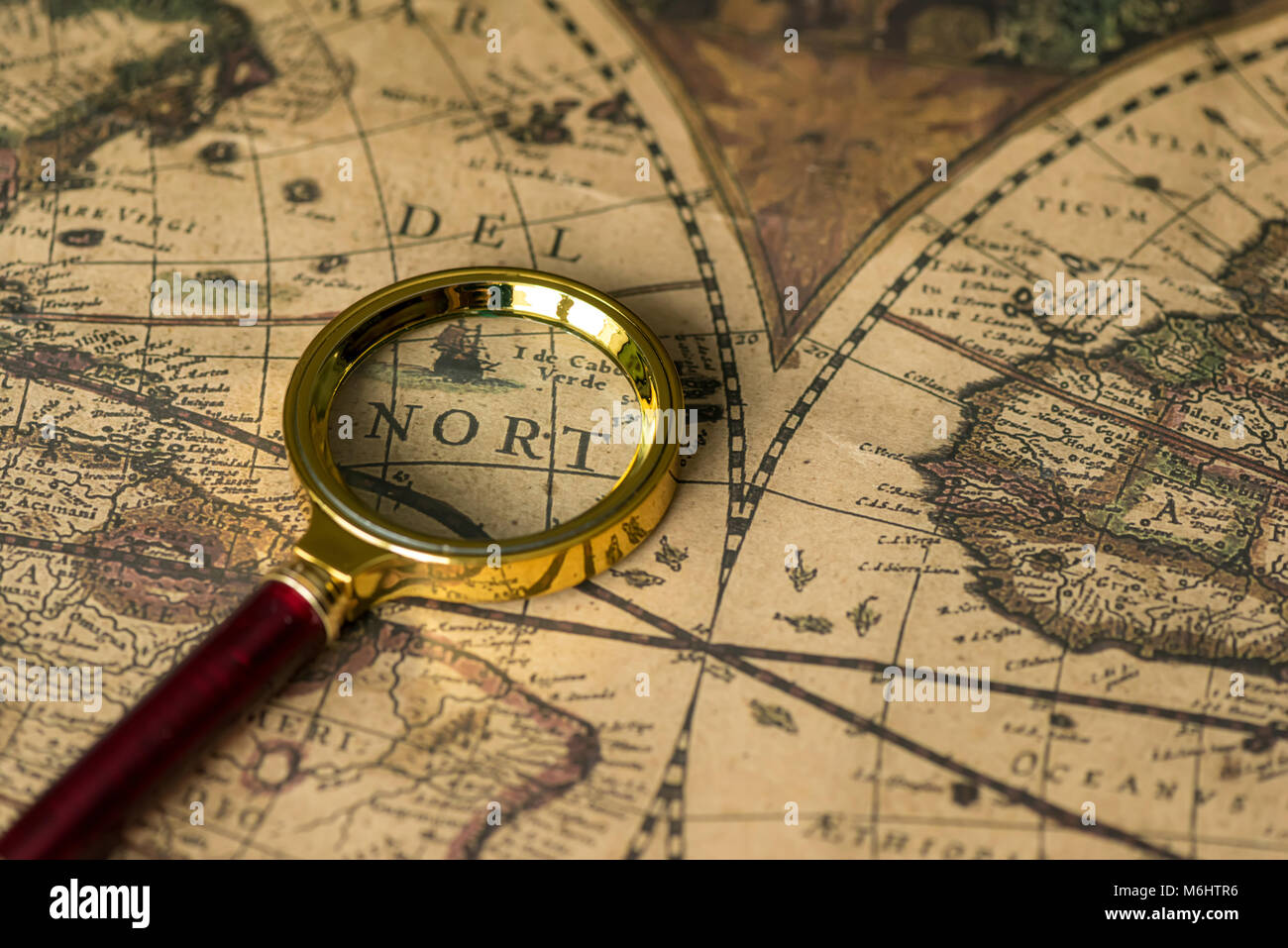 Retro magnifier with old map closeup Stock Photo - Alamy