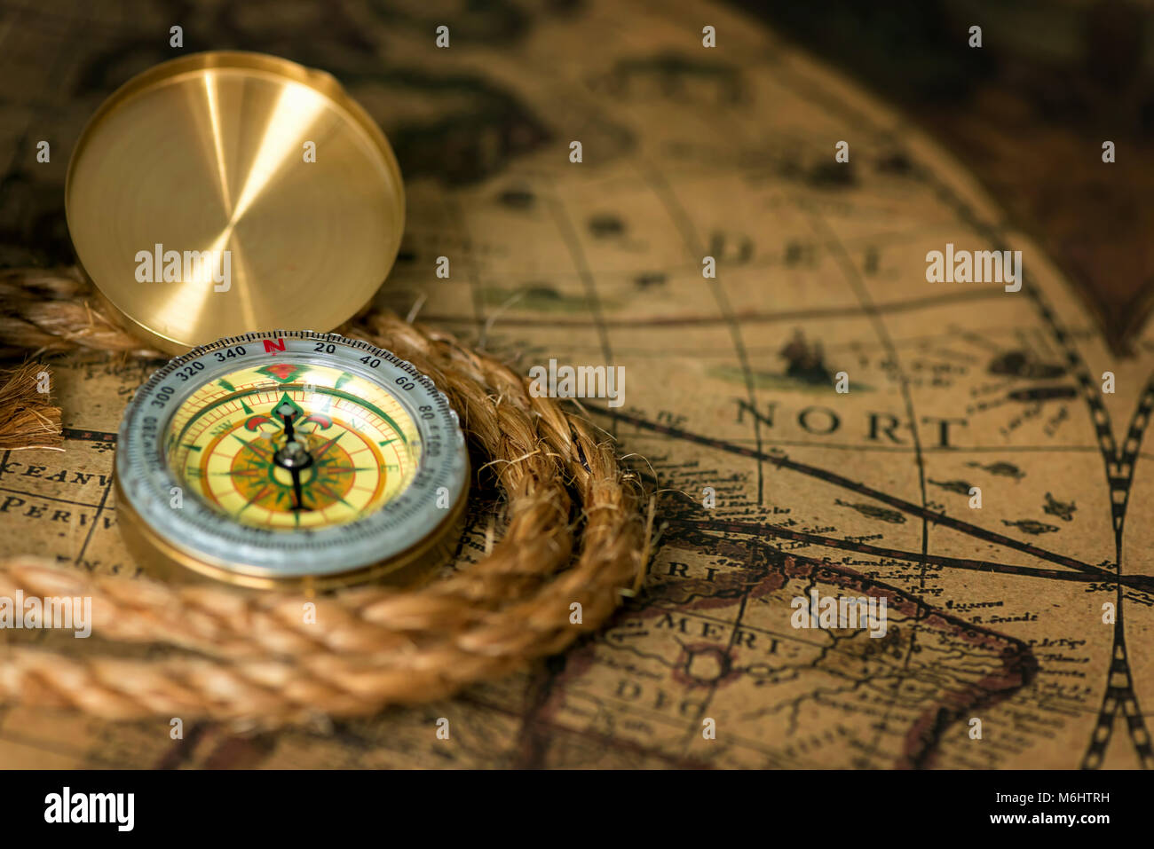 Old compass on vintage map with rope closeup. Retro stale Stock Photo ...