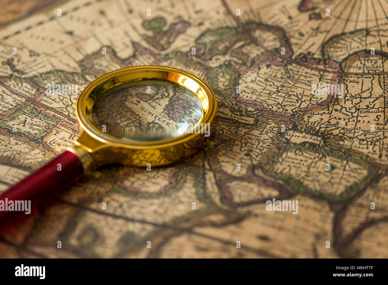 Retro magnifier with old map closeup Stock Photo - Alamy