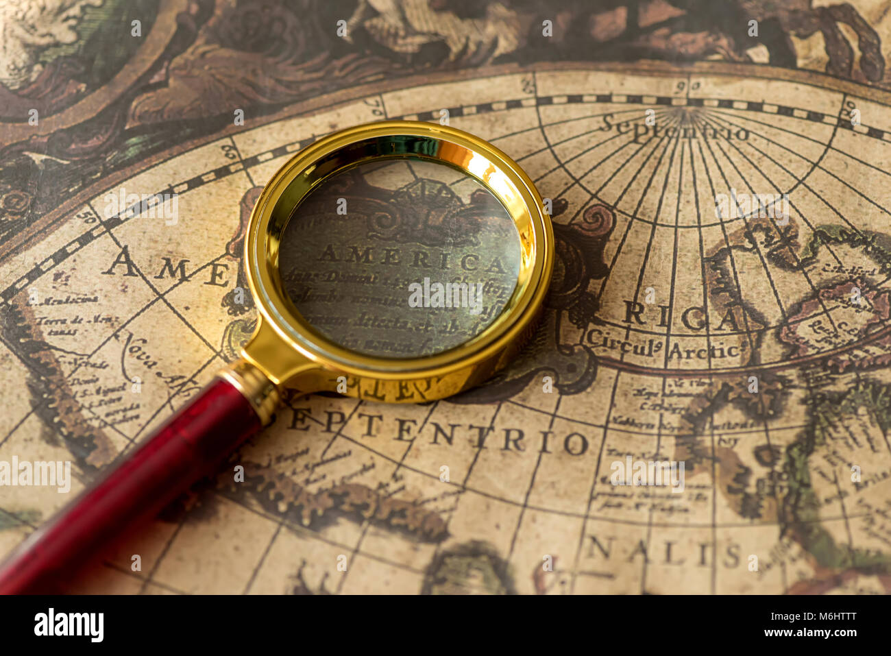 Retro magnifier with old map closeup Stock Photo - Alamy