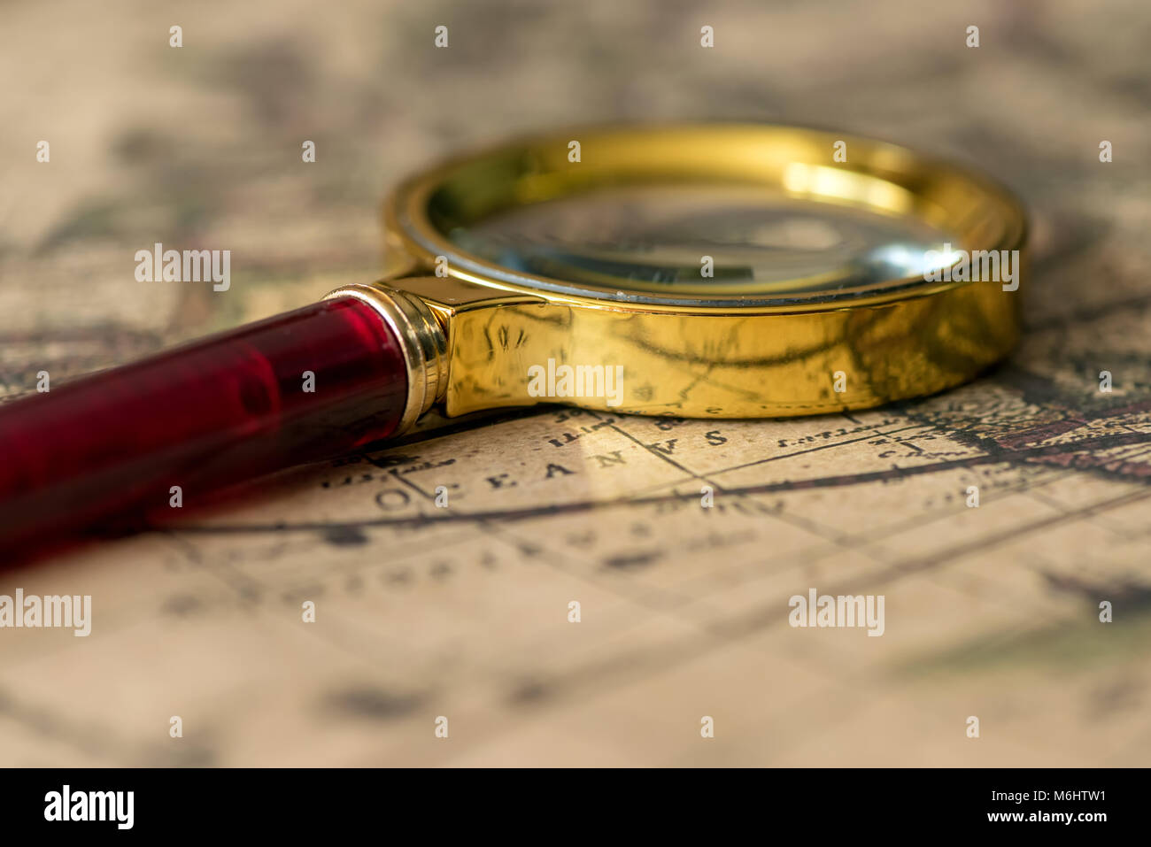 Retro magnifier with old map closeup Stock Photo - Alamy