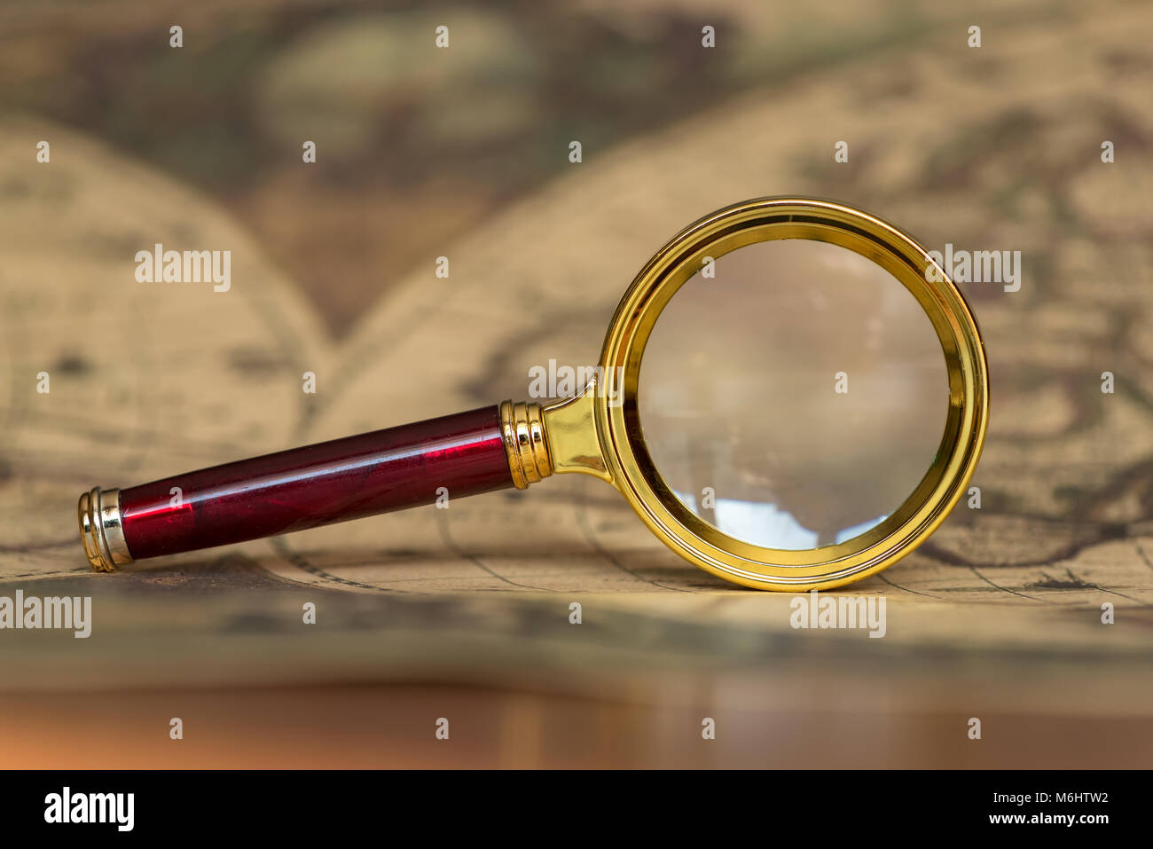 Retro magnifier with old map closeup Stock Photo - Alamy