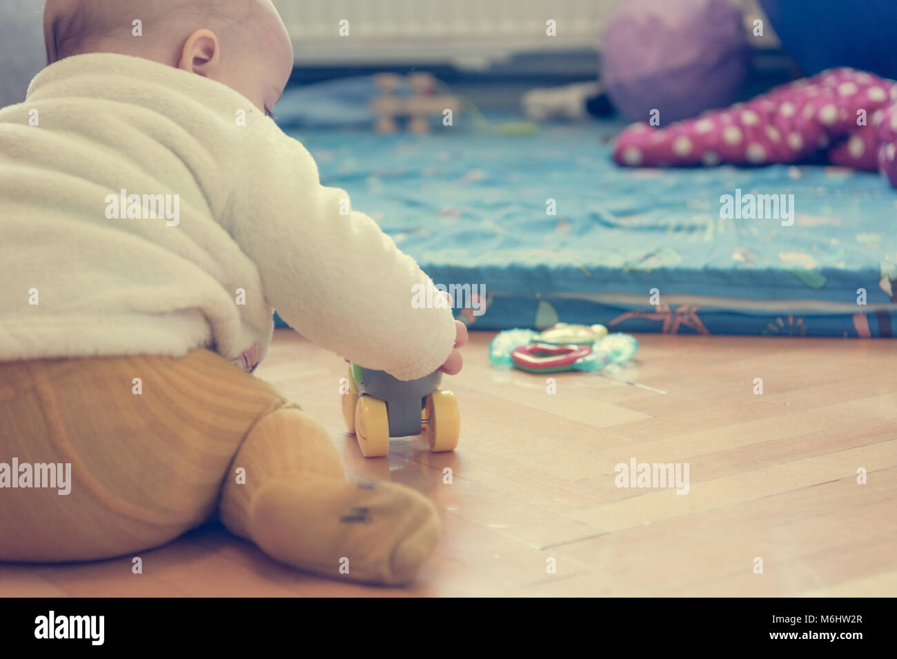 Rear view fo baby playing with toys Stock Photo - Alamy
