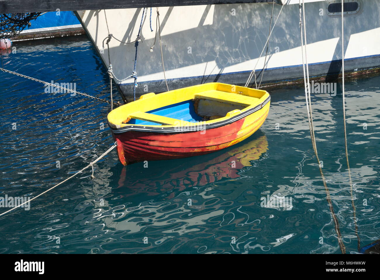 small red-yellow-blue wood boat on the ocean Stock Photo - Alamy