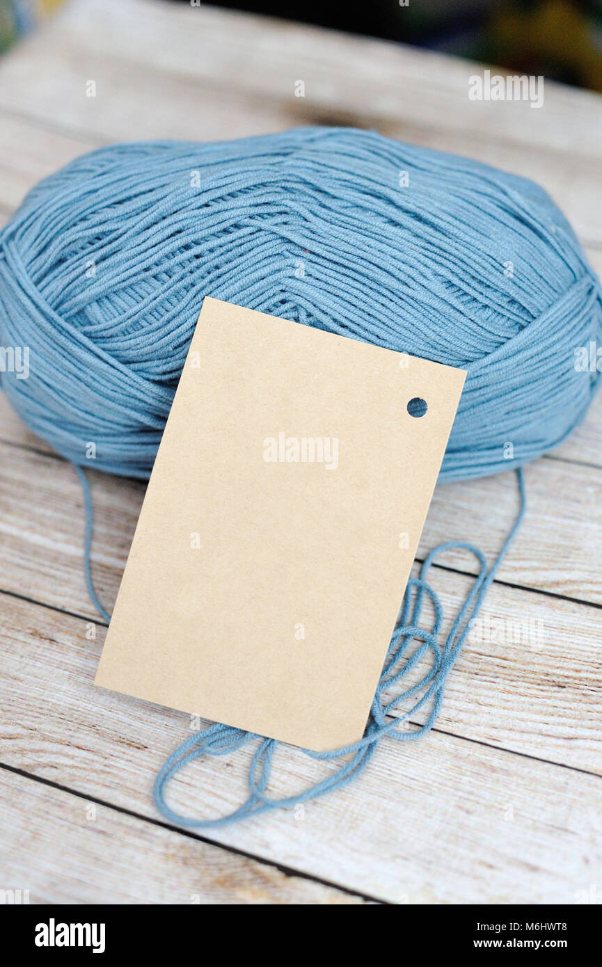 Blank label closeup next to a ball of knitting yarn Stock Photo - Alamy