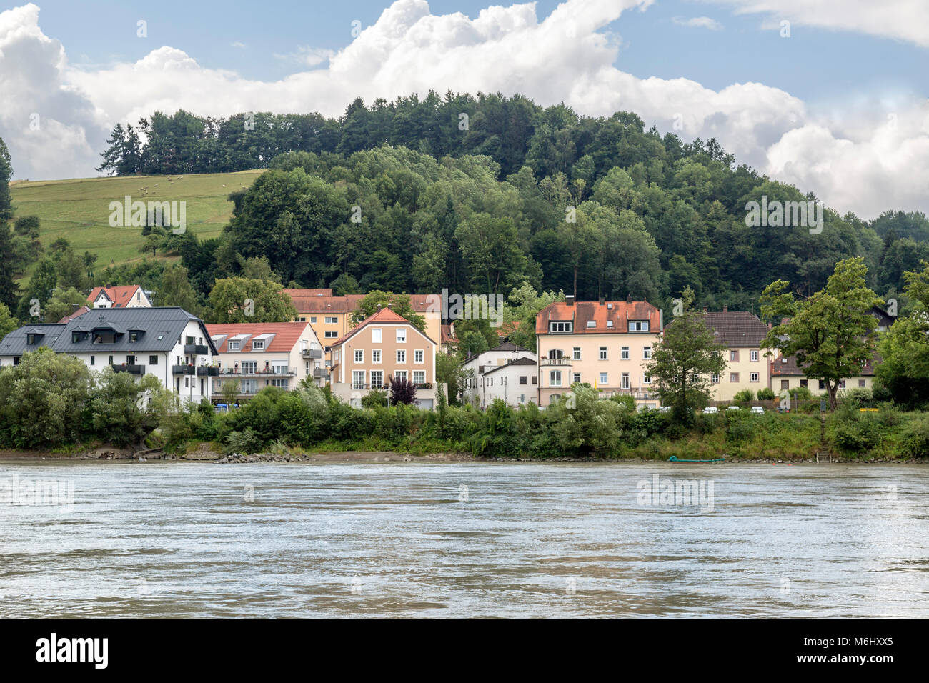 Colorful buildings along the Danube river, with hill beyond in Passau ...