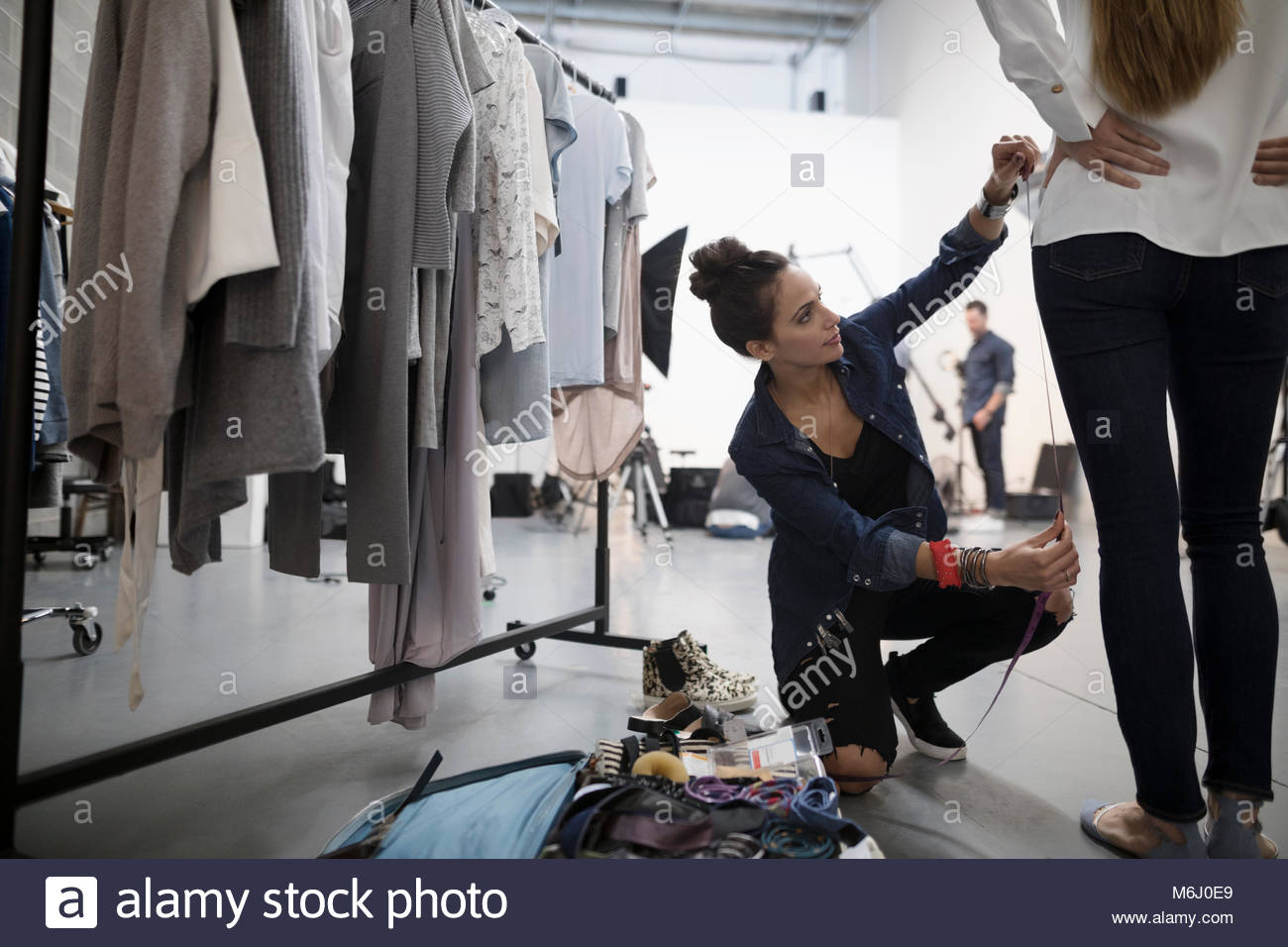 Female wardrobe stylist measuring model for photo shoot in studio Stock ...