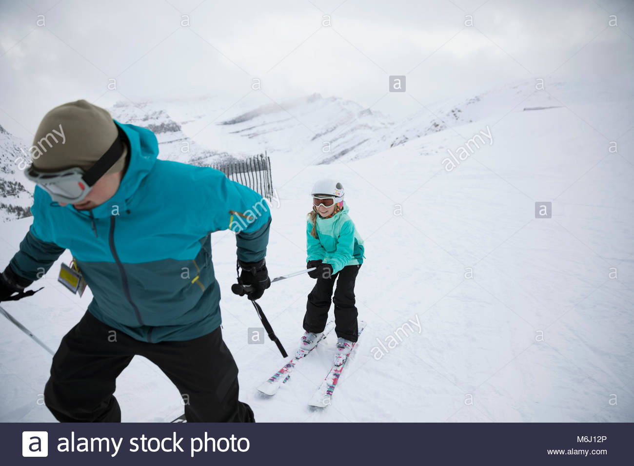Father pulling daughter skier, skiing in snow Stock Photo - Alamy