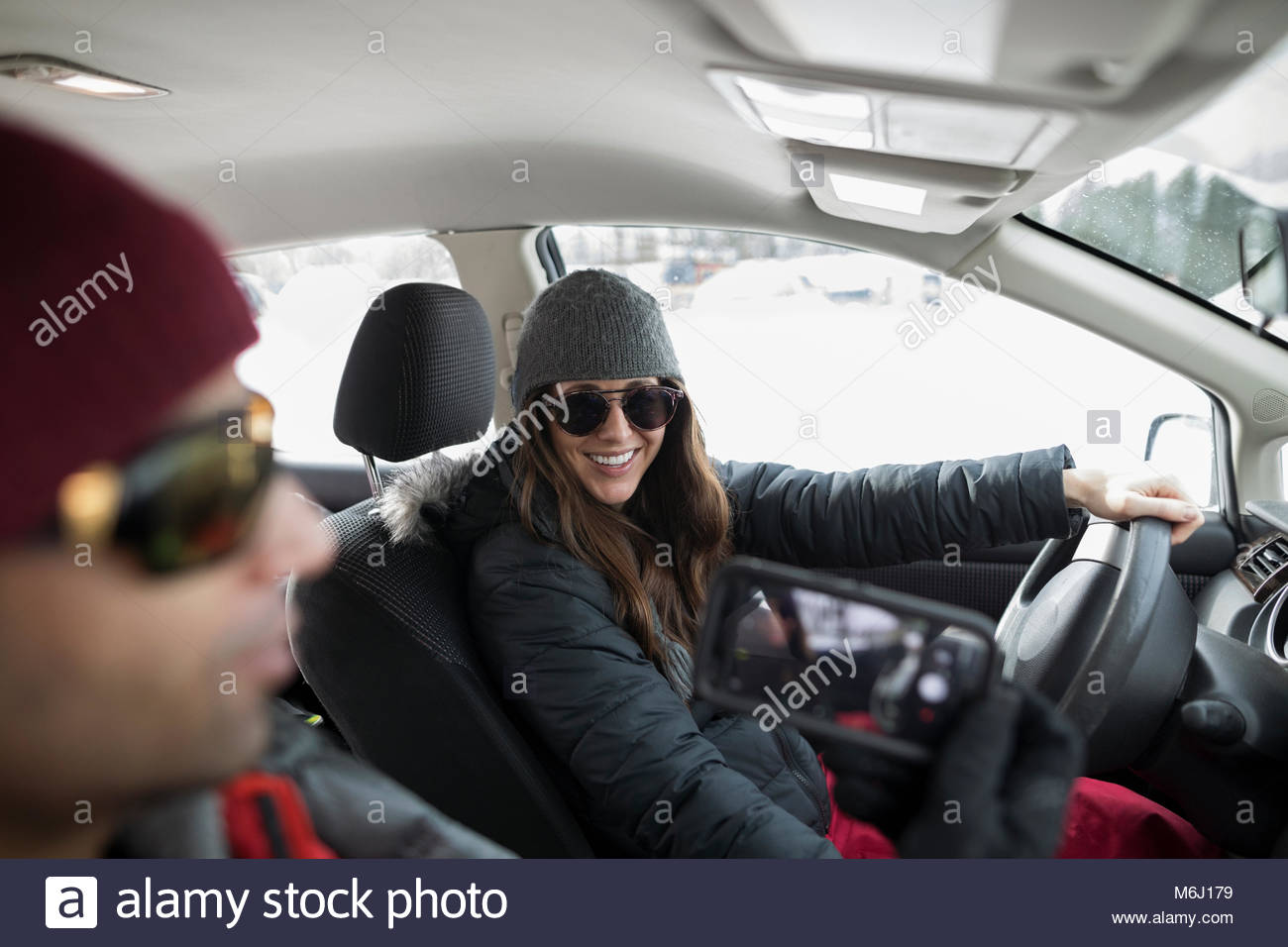 Boyfriend with camera phone photographing girlfriend driving truck ...