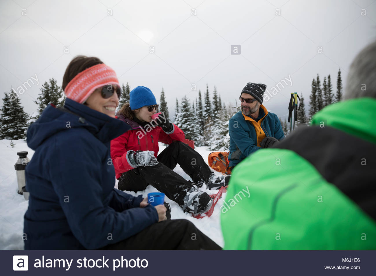 Smiling woman drinking coffee with friends, taking a break from ...