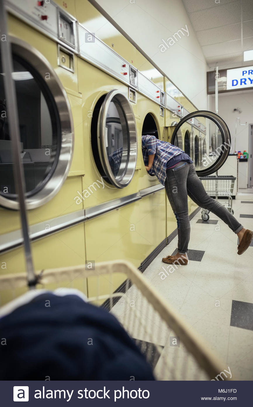 Woman washing her clothes in a laundromat hi-res stock photography and ...