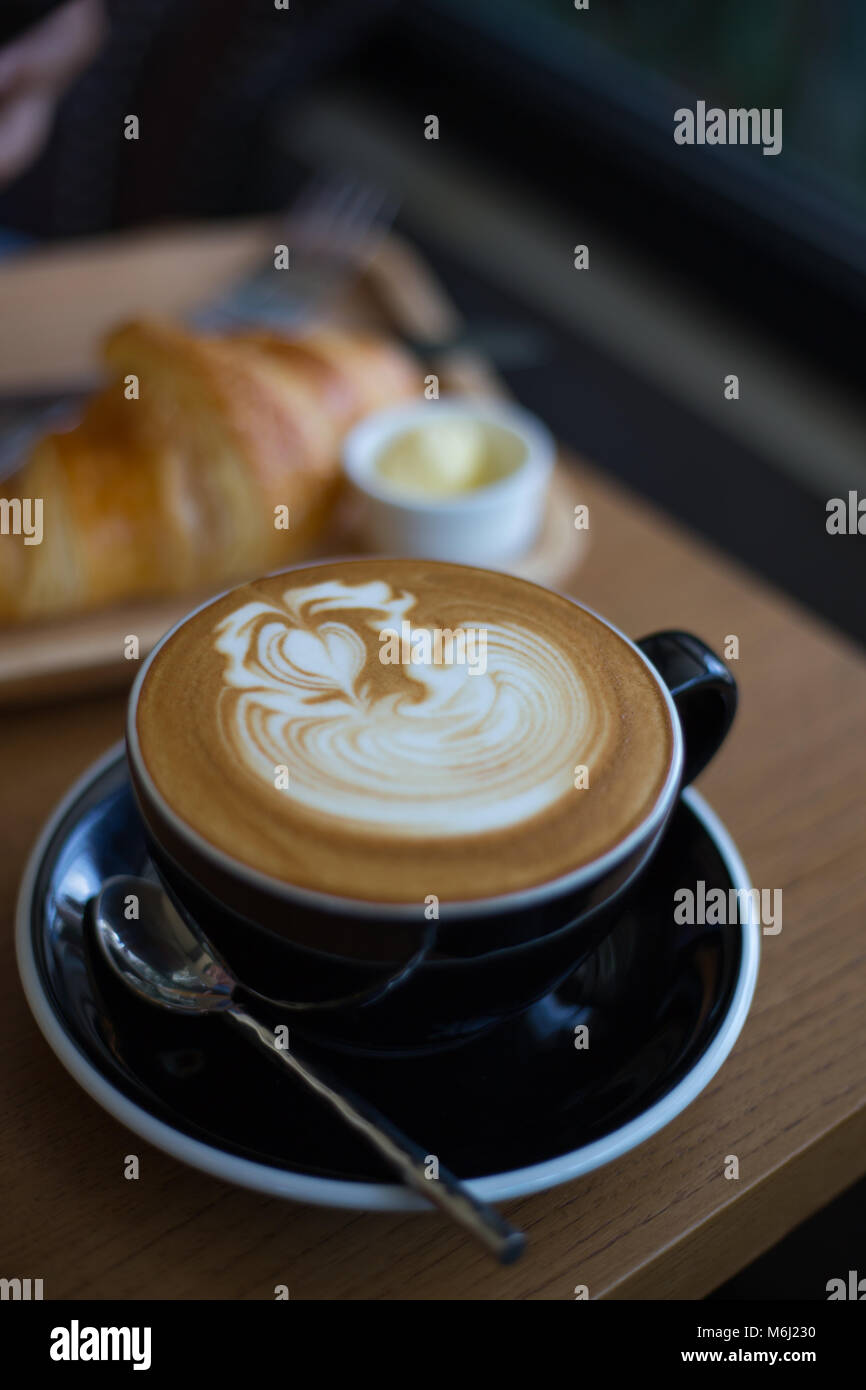 Beautiful latte art coffee in black cup on table of cafe Stock Photo ...