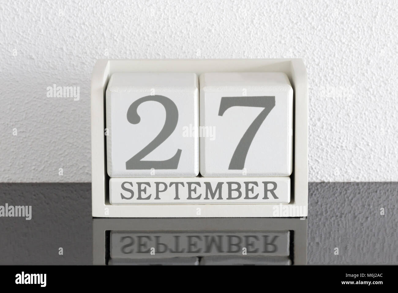White block calendar present date 27 and month September on white wall ...