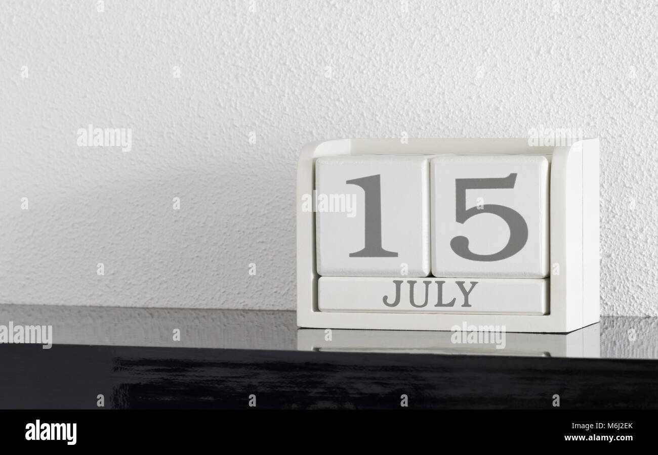 White block calendar present date 15 and month July on white wall ...