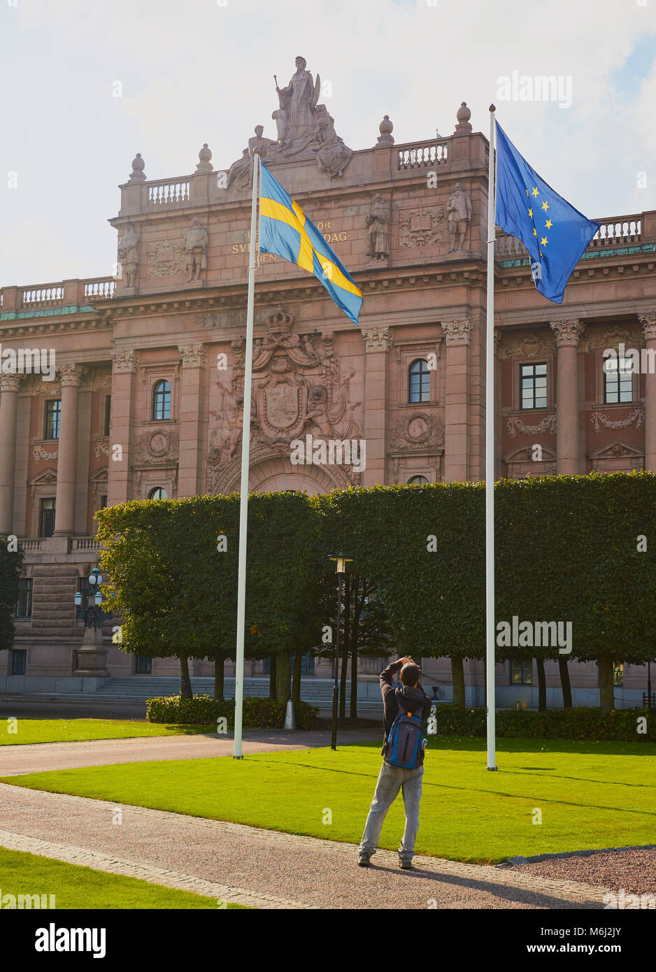 Tourist photographing the Swedish Parliament building, (Riksdagshuset), Helgeandsholmen ...