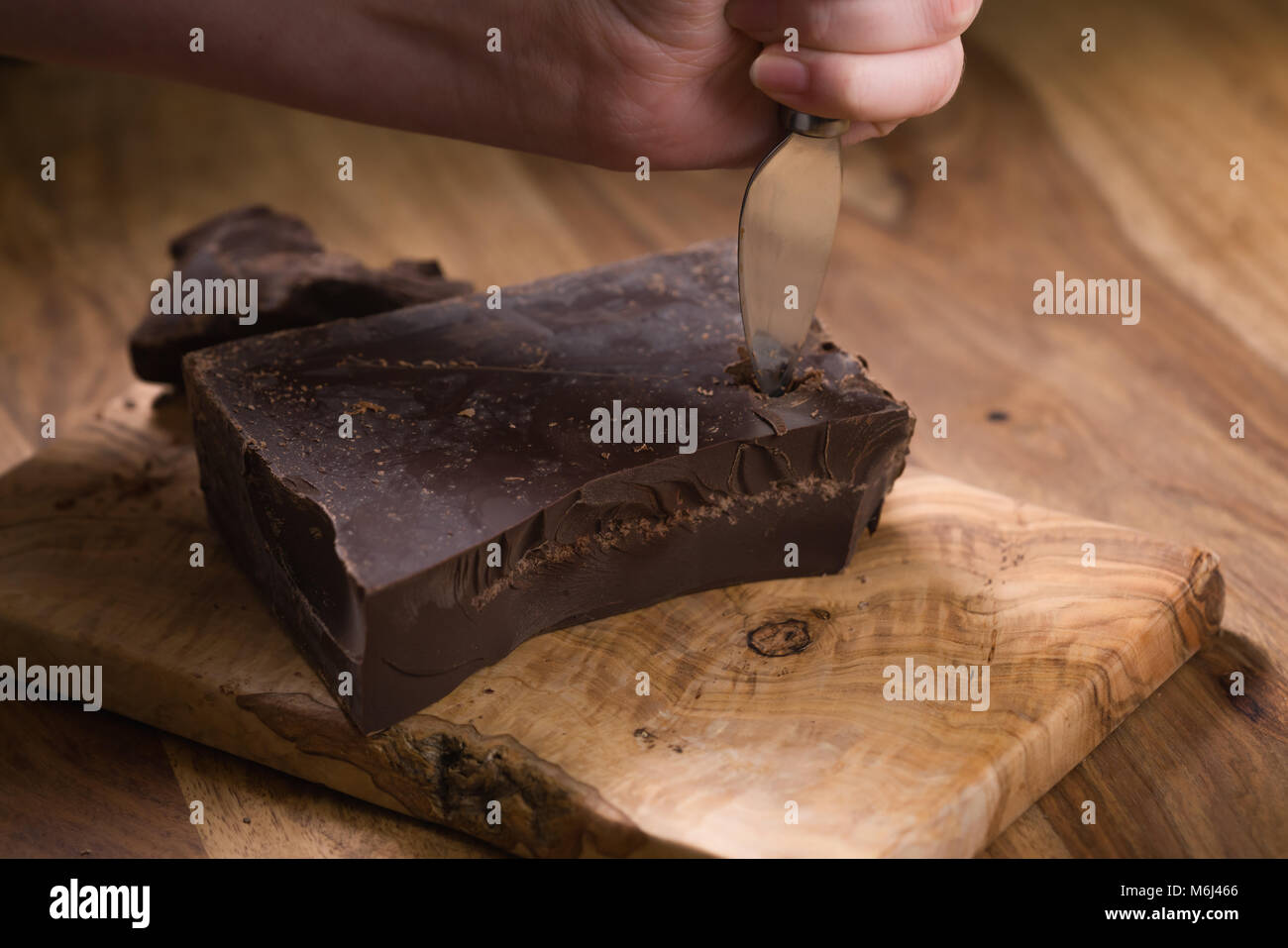 cutting dark chocolate chunks on wood table Stock Photo - Alamy
