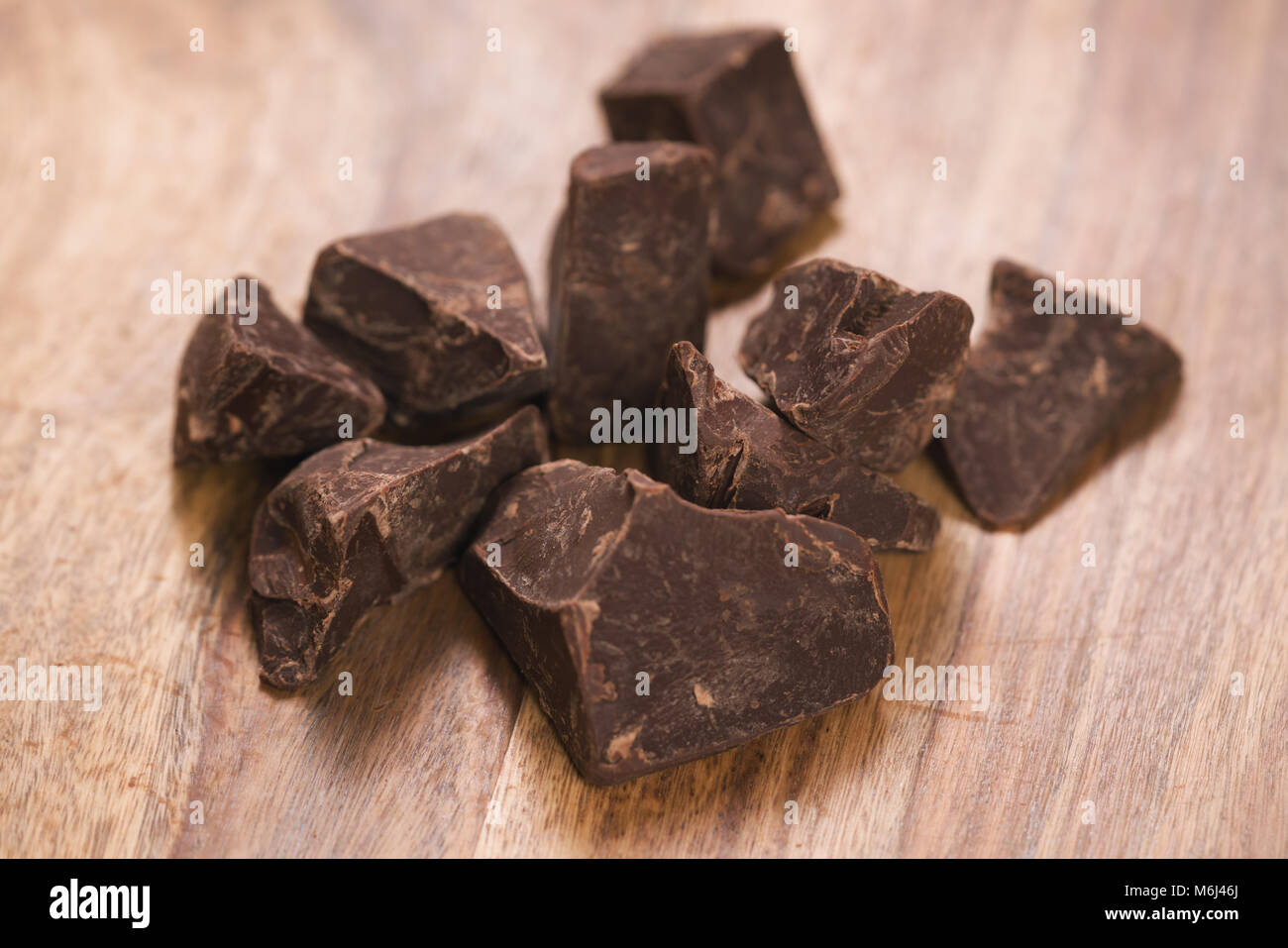 dark chocolate chunks on wood table Stock Photo - Alamy