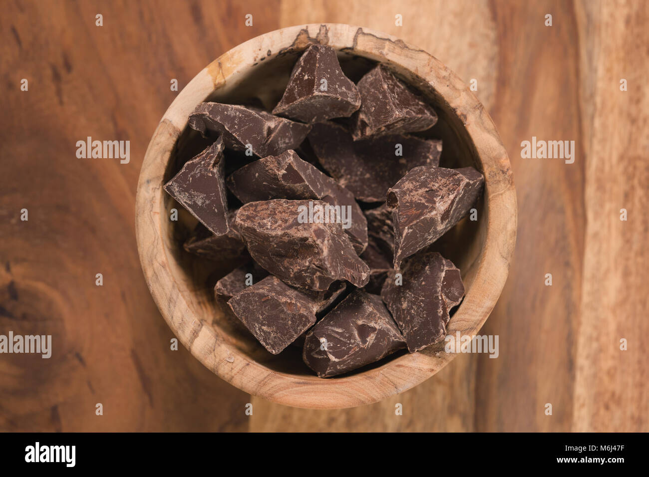 top view dark chocolate chunks in wood bowl on table Stock Photo - Alamy