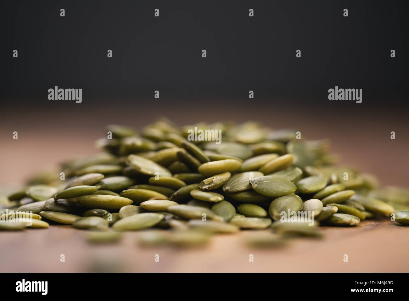 green pumkin seeds on wooden table Stock Photo - Alamy