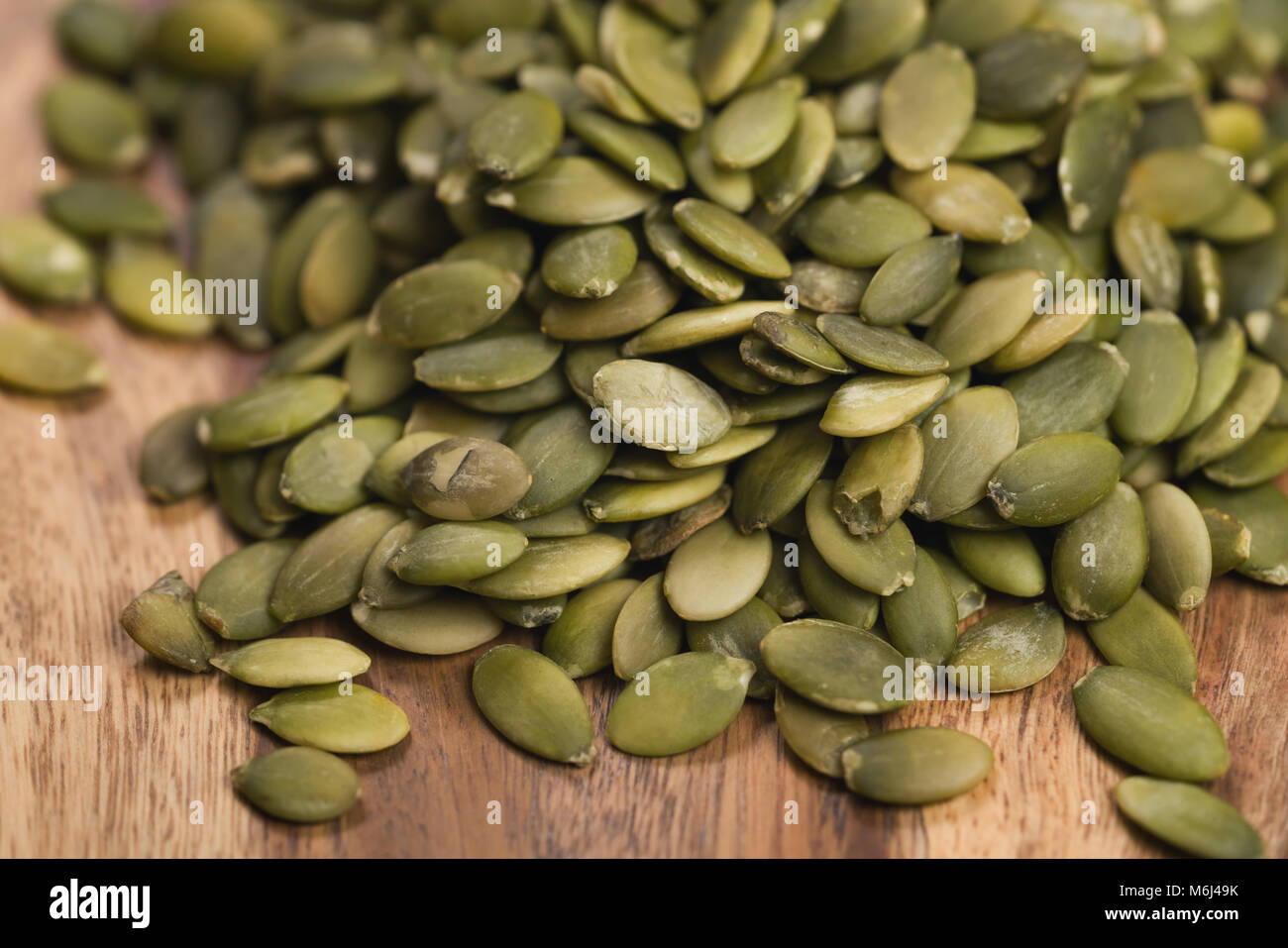 green pumkin seeds on wooden table Stock Photo - Alamy